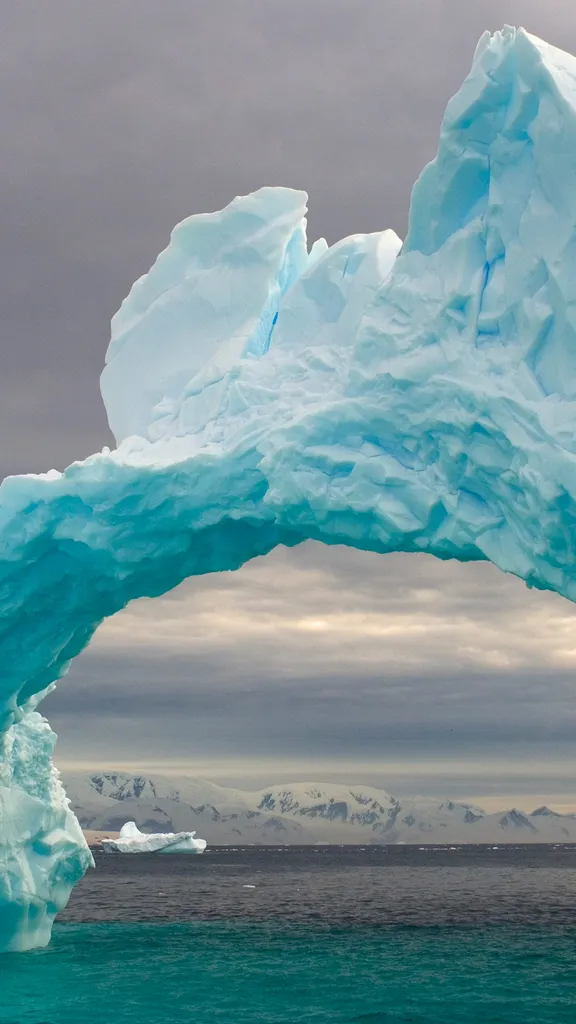 Arched iceberg floating off the western Antarctic Peninsula, Southern ...